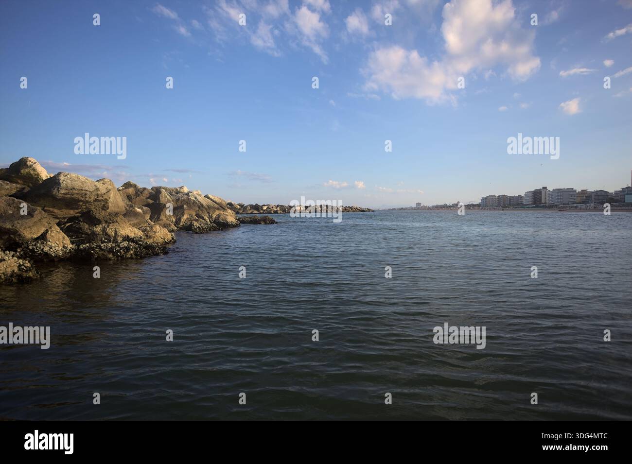 Breakwater near a beach by the seaside at sunset on a clear and sunny ...