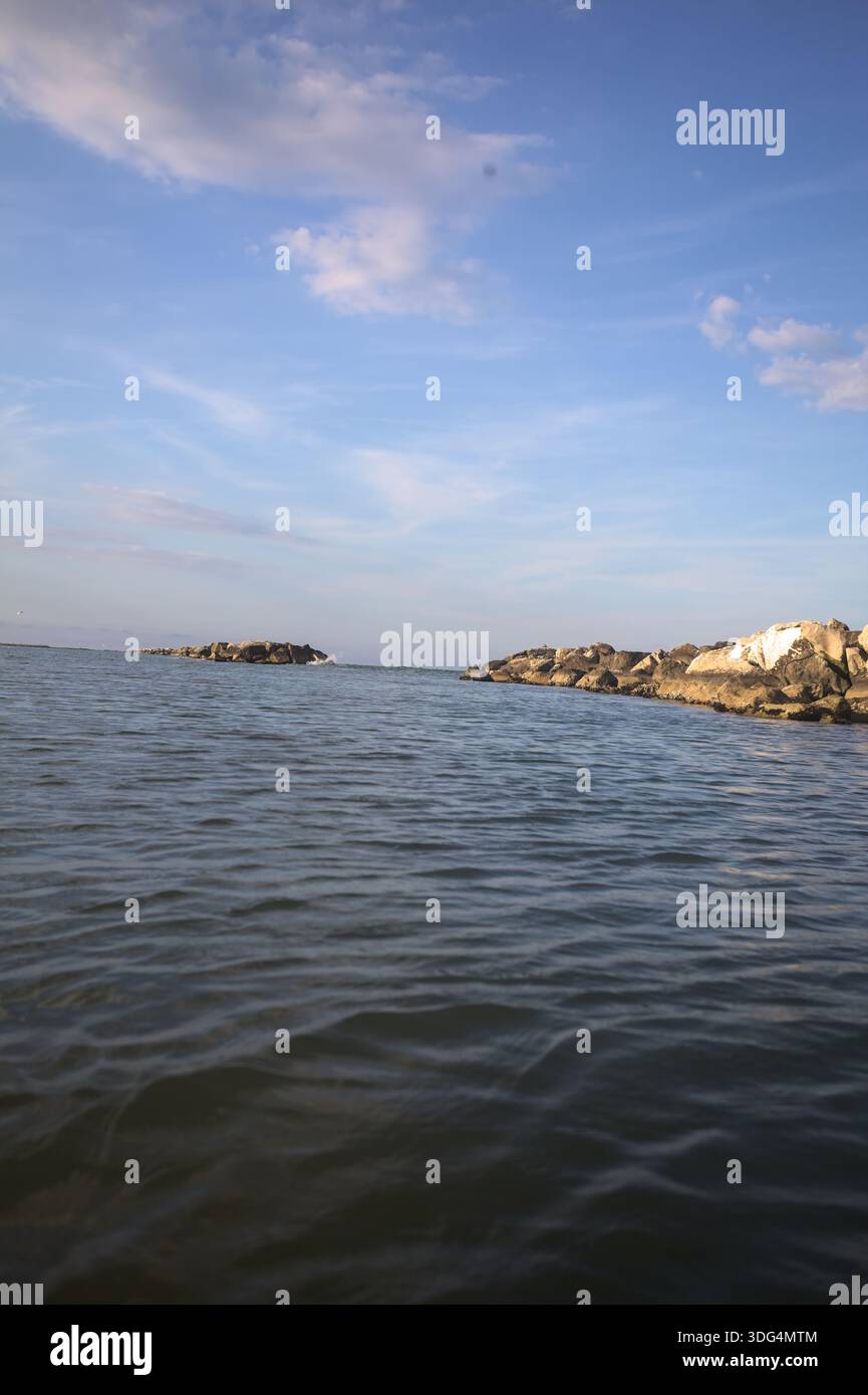 Breakwater near a beach by the seaside at sunset on a clear and sunny ...