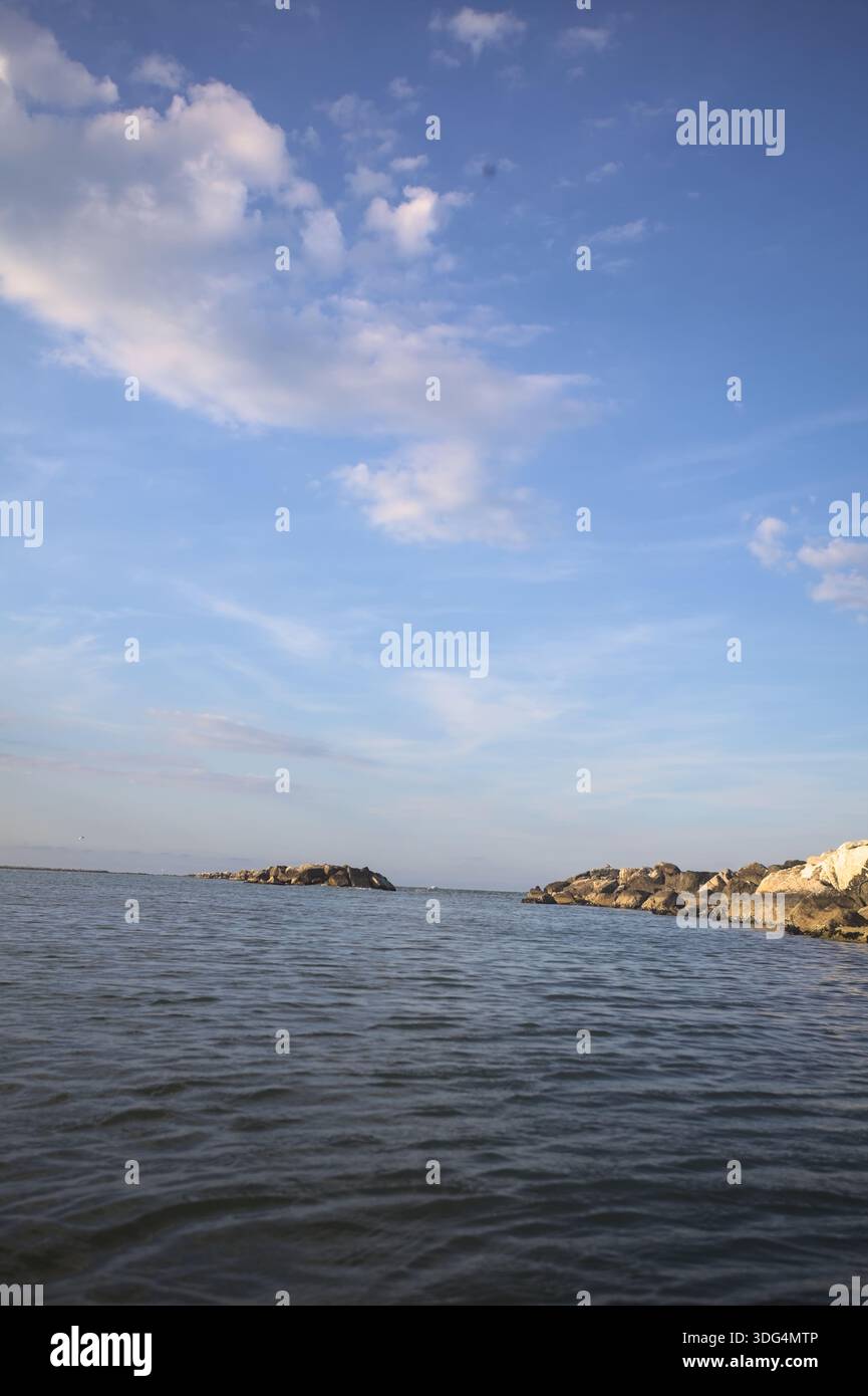 Breakwater near a beach by the seaside at sunset on a clear and sunny ...