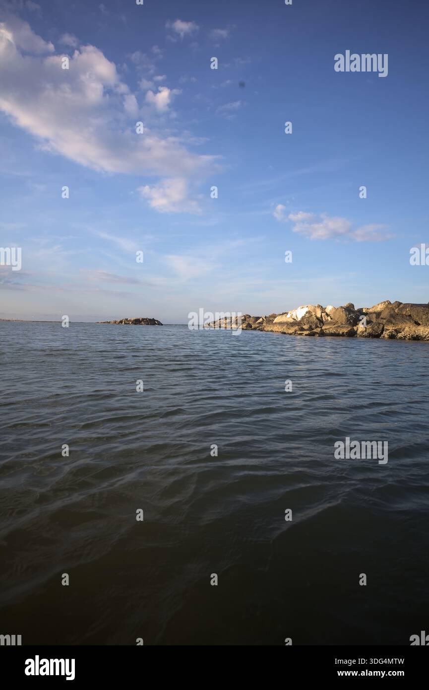 Breakwater near a beach by the seaside at sunset on a clear and sunny ...