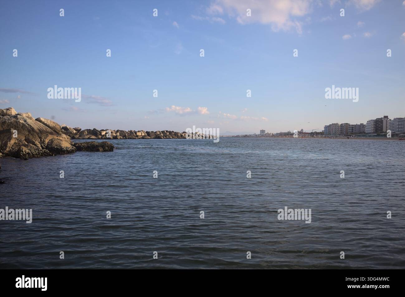 Breakwater near a beach by the seaside at sunset on a clear and sunny ...