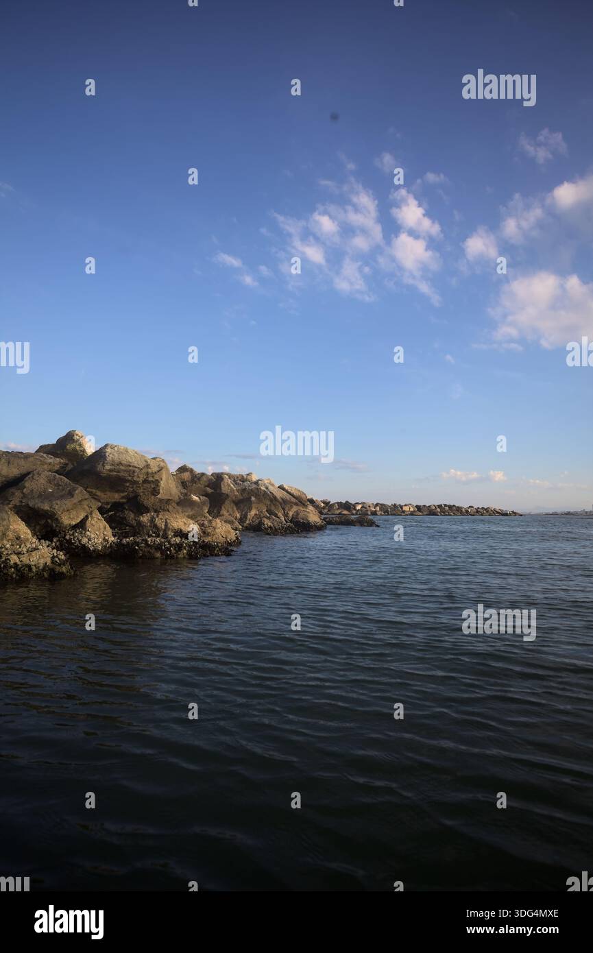 Breakwater near a beach by the seaside at sunset on a clear and sunny ...