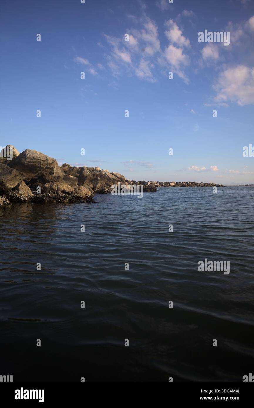 Breakwater near a beach by the seaside at sunset on a clear and sunny ...