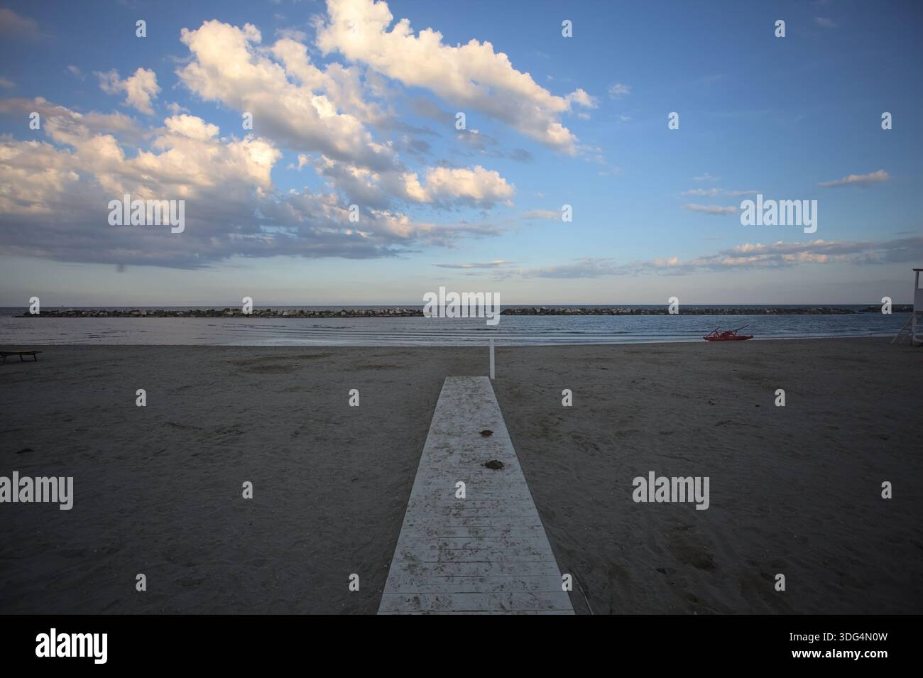 Strip on an empty beach resort at sunset with the sea stretching to the ...