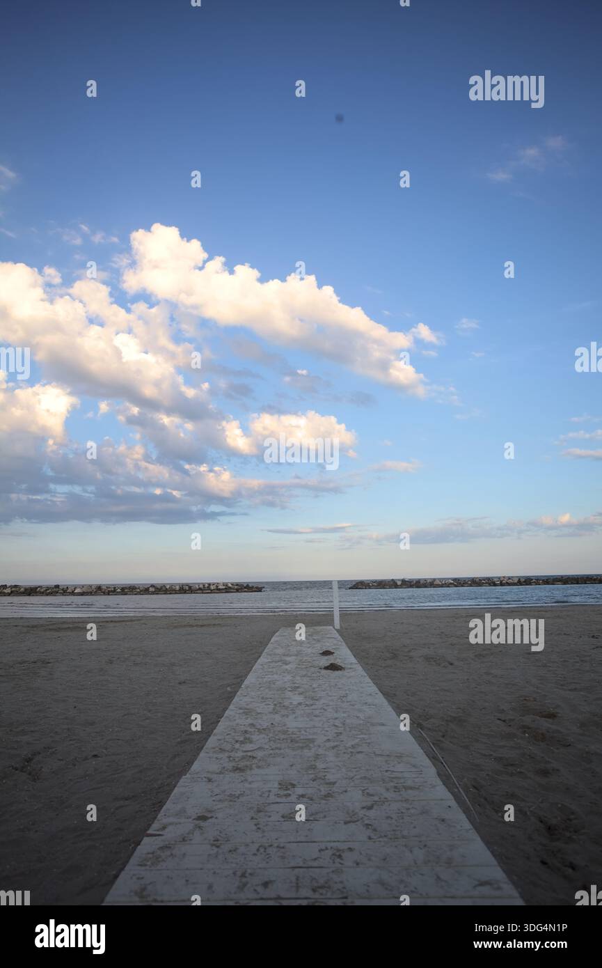 Strip on an empty beach resort at sunset with the sea stretching to the ...