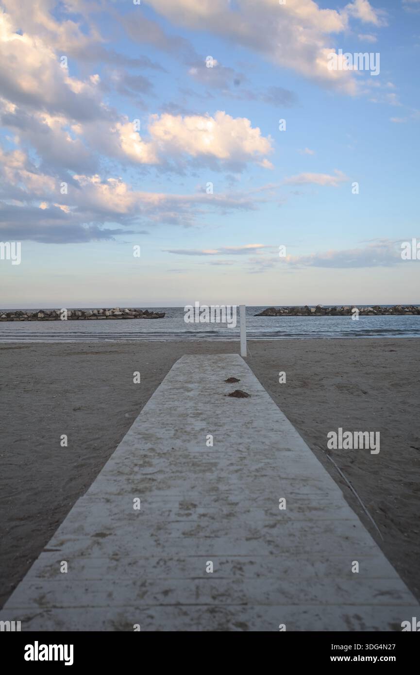 Strip on an empty beach resort at sunset with the sea stretching to the ...