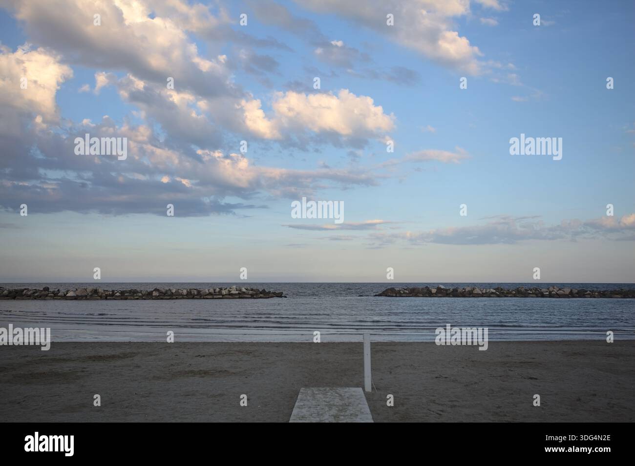 Strip on an empty beach resort at sunset with the sea stretching to the ...