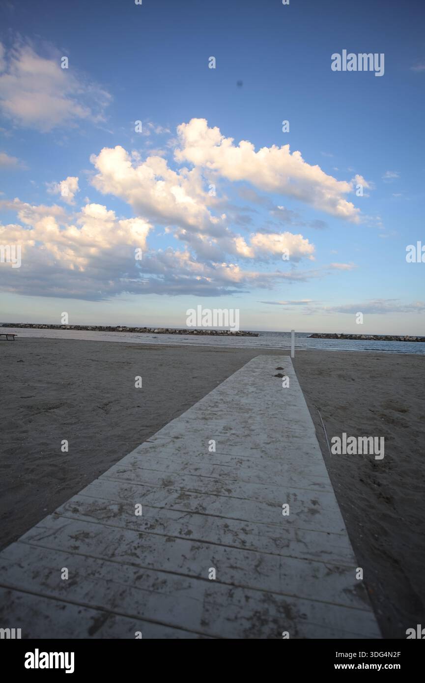 Strip on an empty beach resort at sunset with the sea stretching to the ...