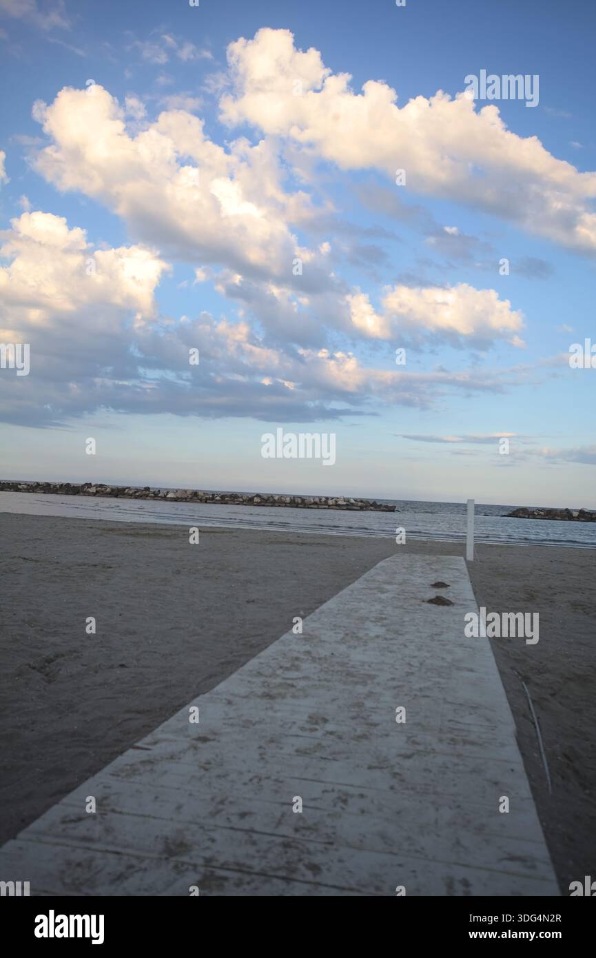 Strip on an empty beach resort at sunset with the sea stretching to the ...