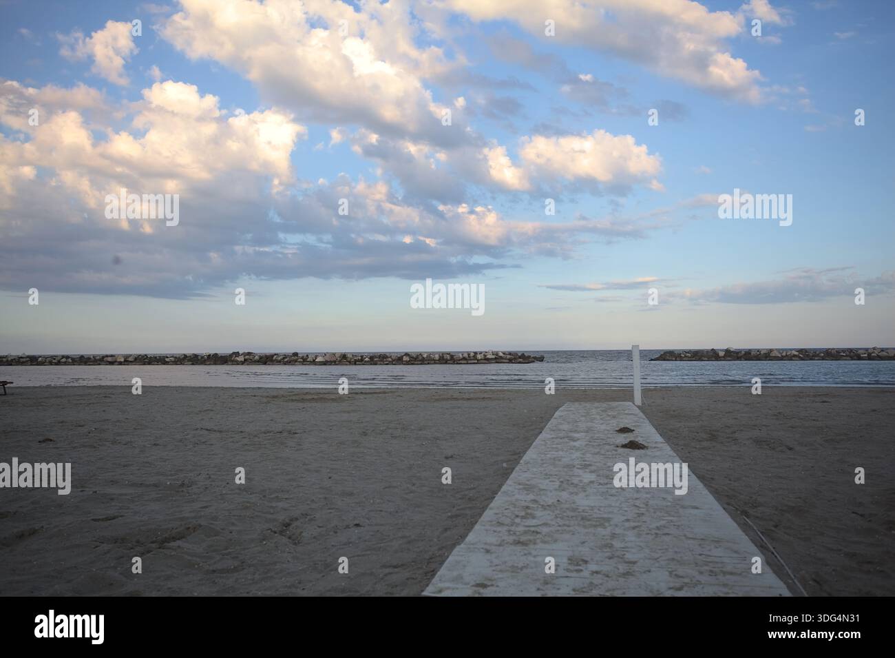 Strip on an empty beach resort at sunset with the sea stretching to the ...