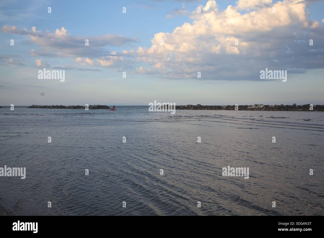 Breakwater on the horizon by the seaside at sunset Stock Photo - Alamy