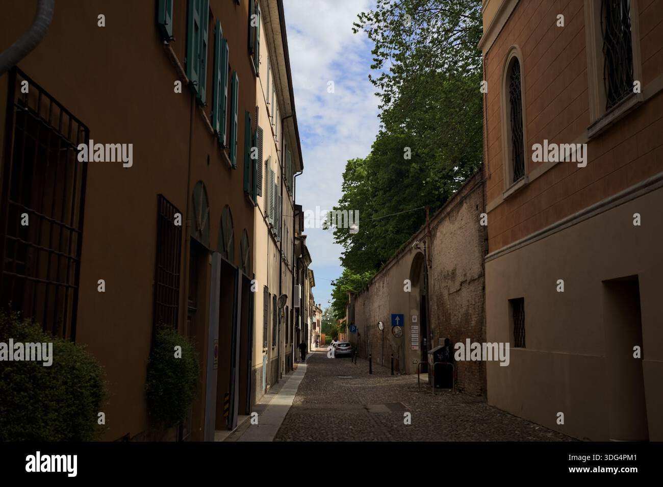 Narrow cobbled alley partially in the shade in an italian town seen ...