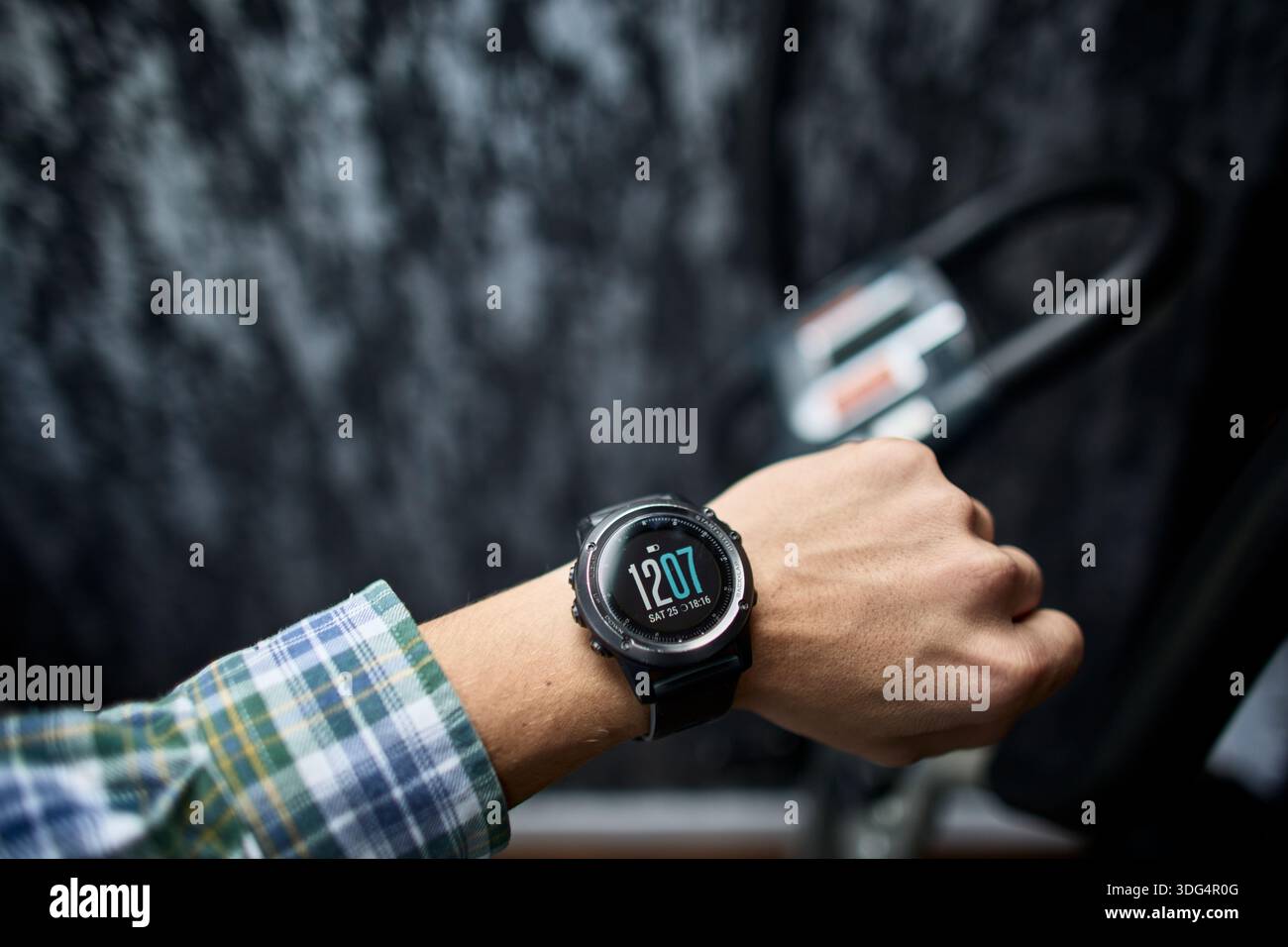 Close-up view of a modern smartwatch worn on a human wrist. The device ...