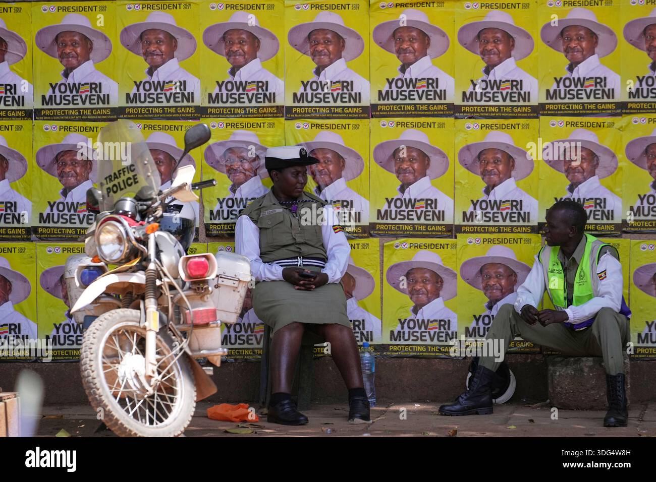 Traffic police officers sit in front of campaign posters of President ...