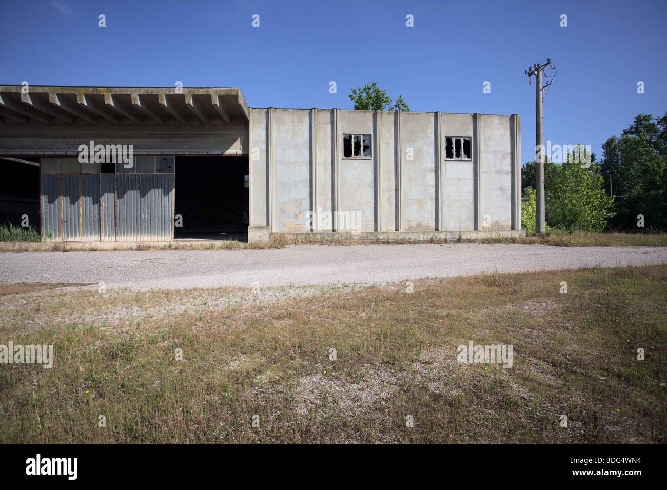 Warehouses of an abandoned compound surrounded by trees on a sunny day ...