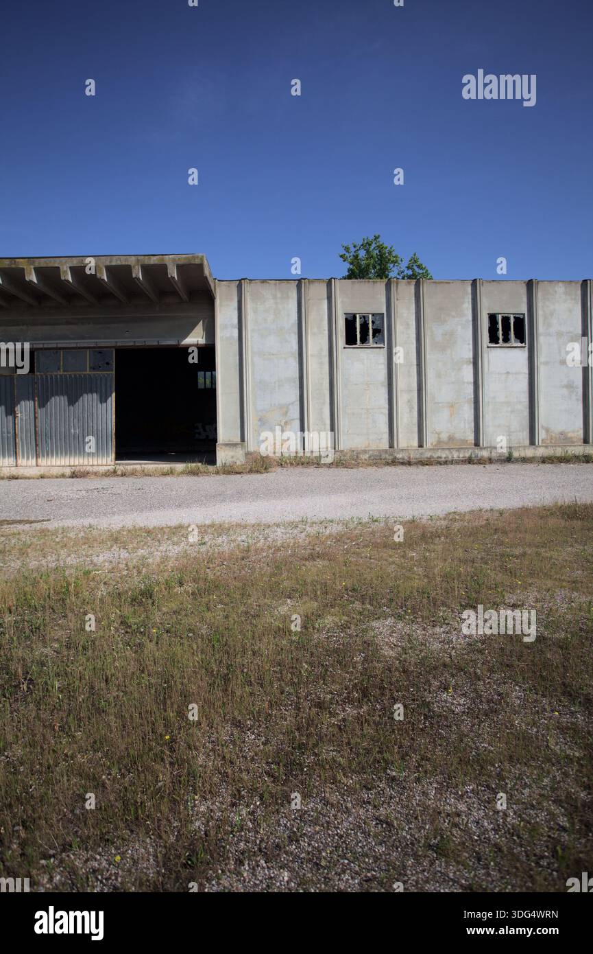 Warehouses of an abandoned compound surrounded by trees on a sunny day ...