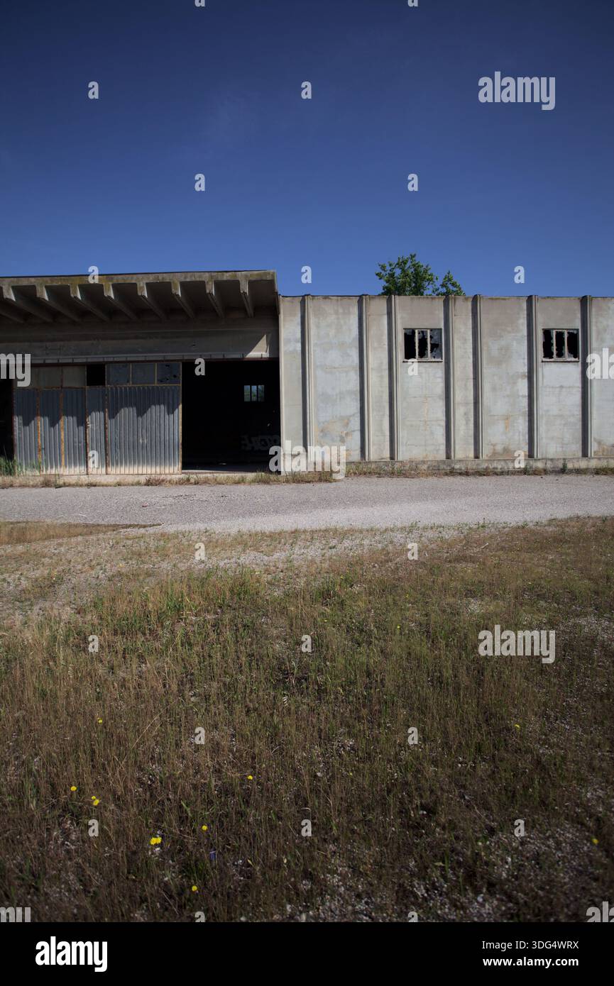 Warehouses of an abandoned compound surrounded by trees on a sunny day ...