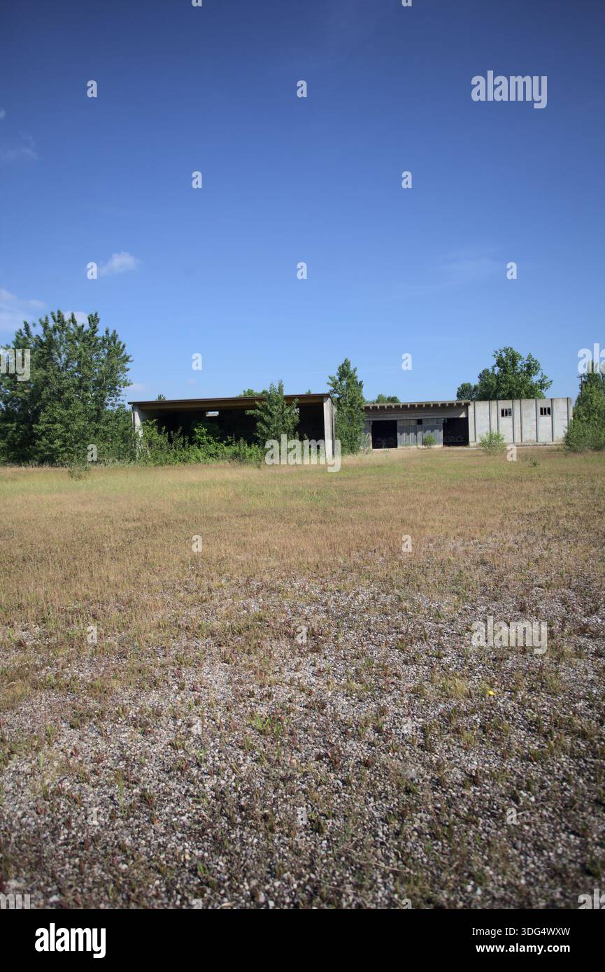 Warehouses of an abandoned compound surrounded by trees on a sunny day ...
