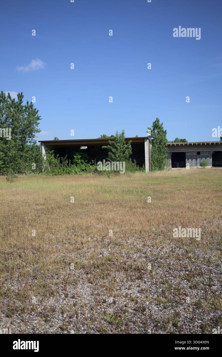 Warehouses of an abandoned compound surrounded by trees on a sunny day ...