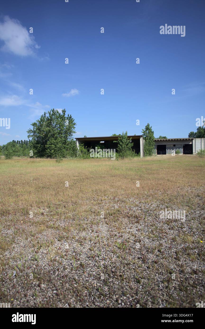 Warehouses of an abandoned compound surrounded by trees on a sunny day ...