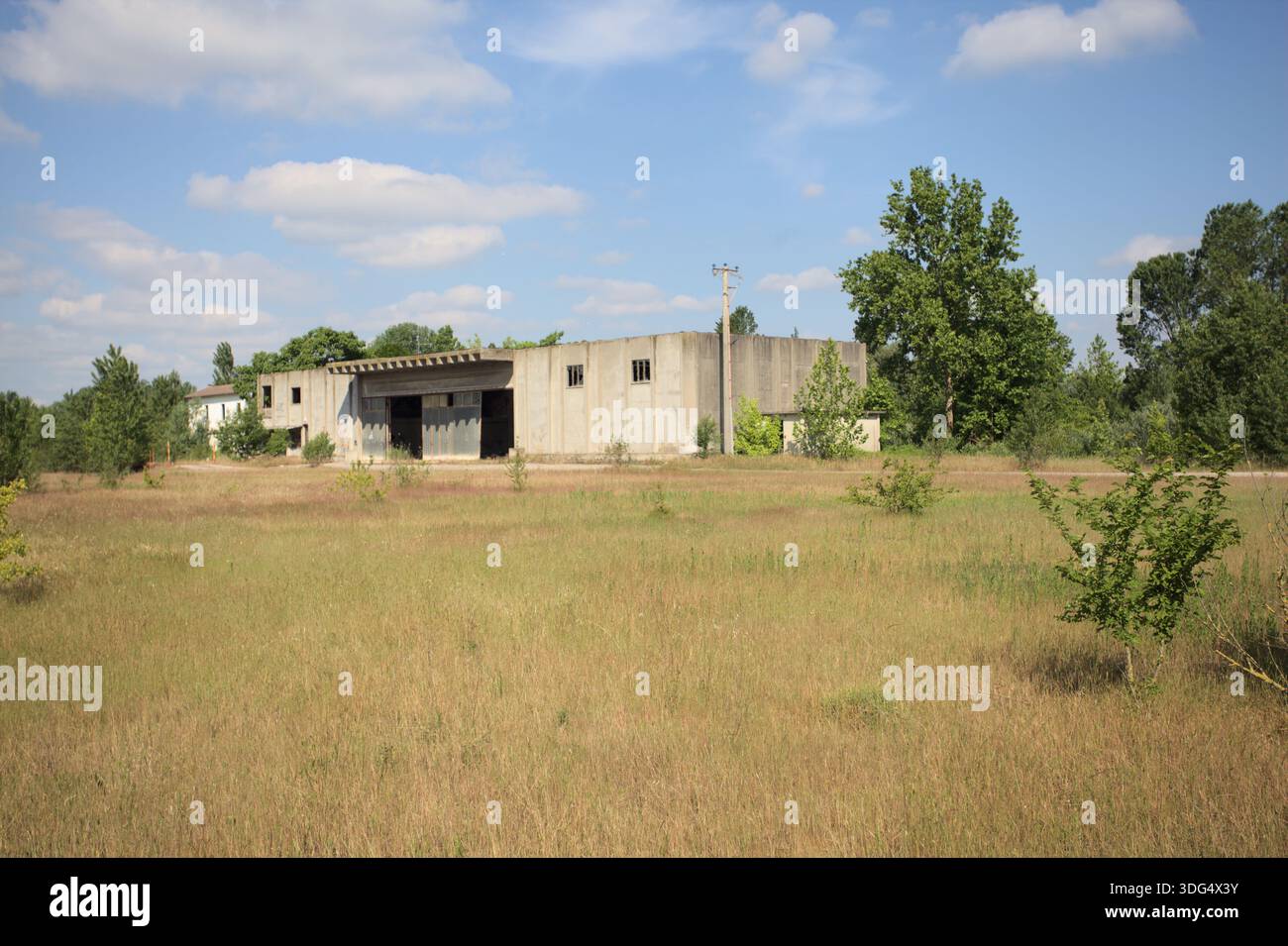 Warehouses of an abandoned compound surrounded by trees on a sunny day ...