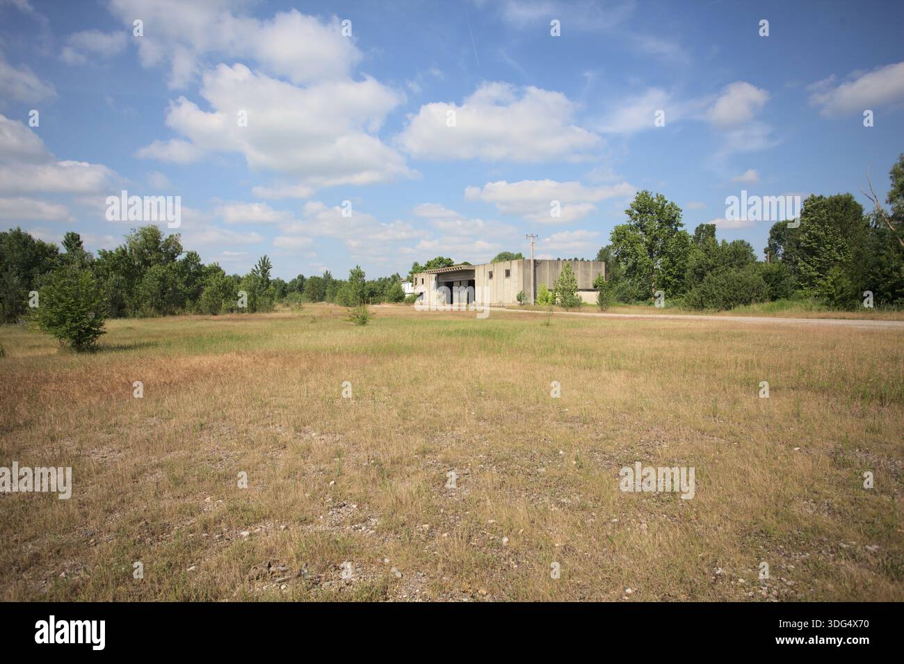 Warehouses of an abandoned compound surrounded by trees on a sunny day ...