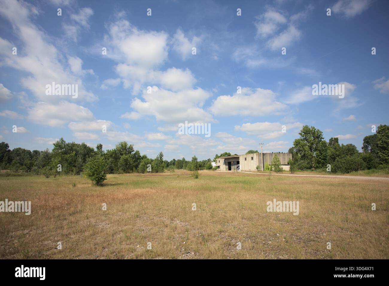 Warehouses of an abandoned compound surrounded by trees on a sunny day ...