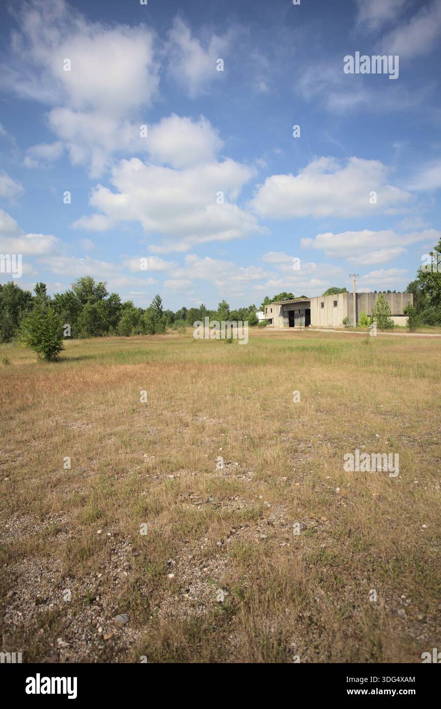 Warehouses of an abandoned compound surrounded by trees on a sunny day ...