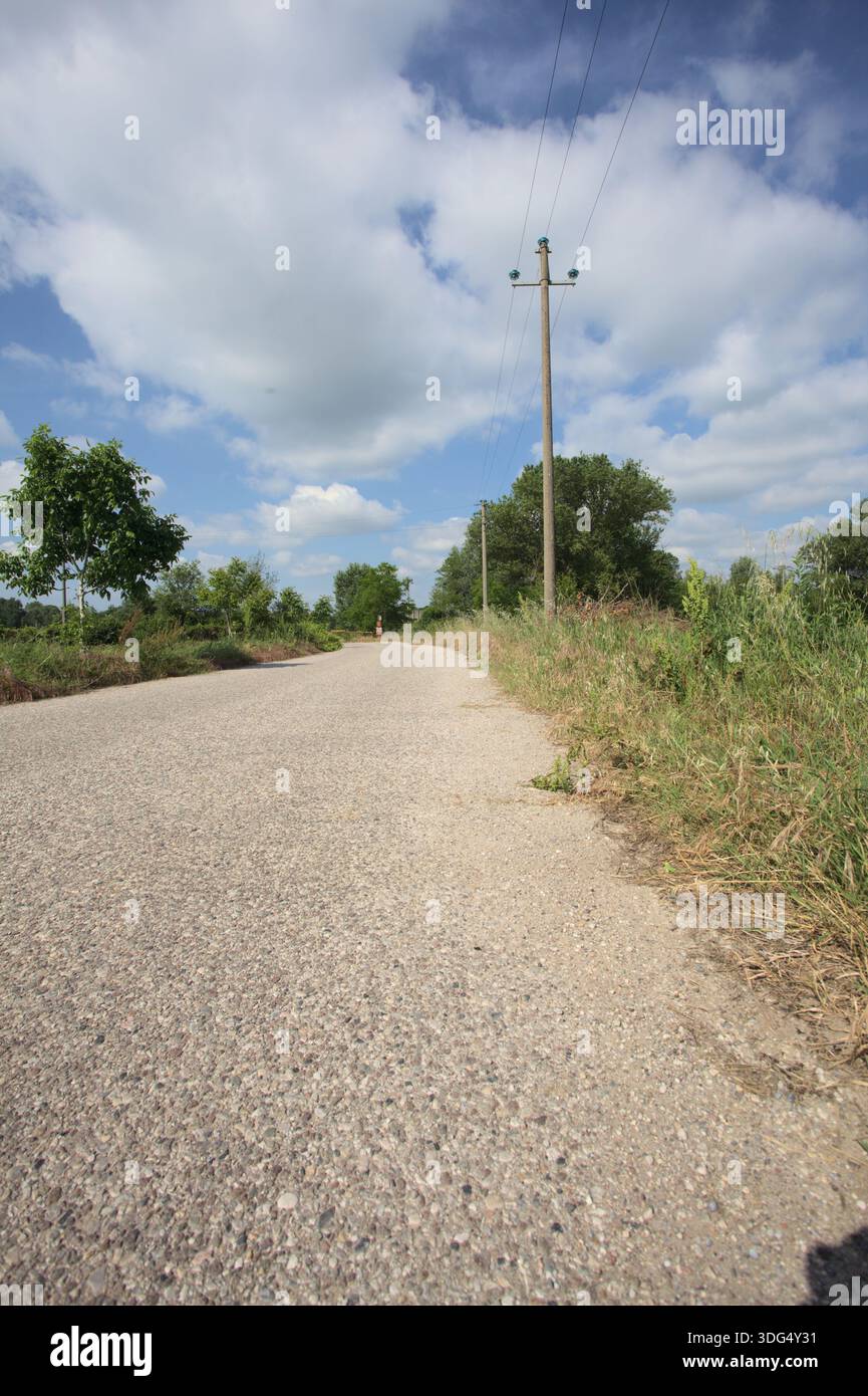 Dirt road between fields with an overhead power line by its edge ...