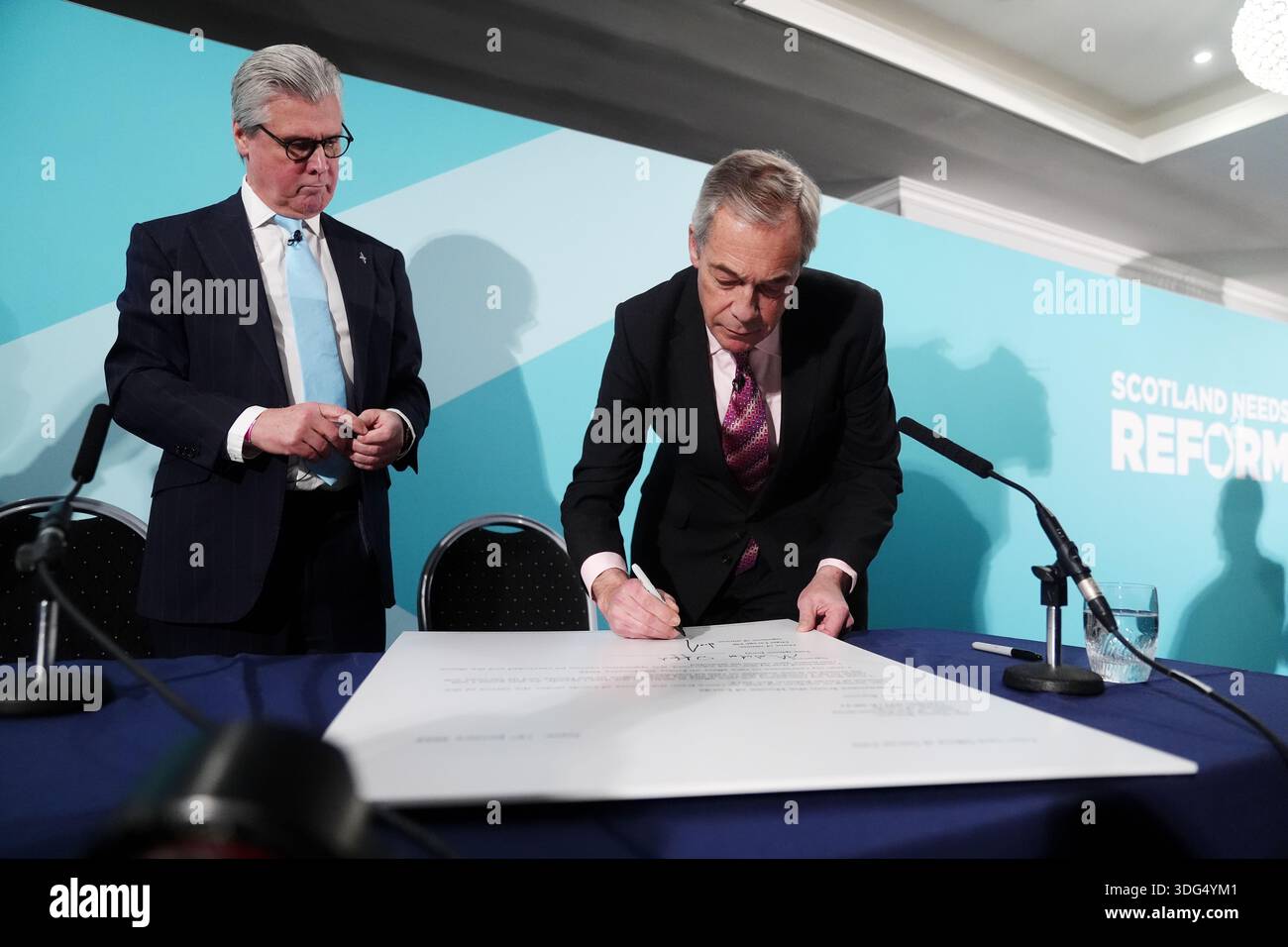 Reform UK leader Nigel Farage signs Malcolm Offord's (left) house of ...