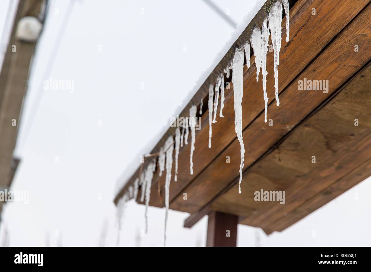 Icicles hang on the roof in winter. Selective focus. nature Stock Photo ...