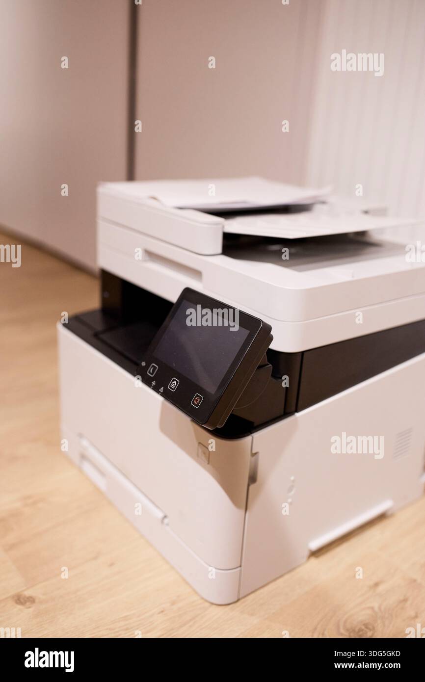 Modern office printer placed in a professional workspace. The image ...