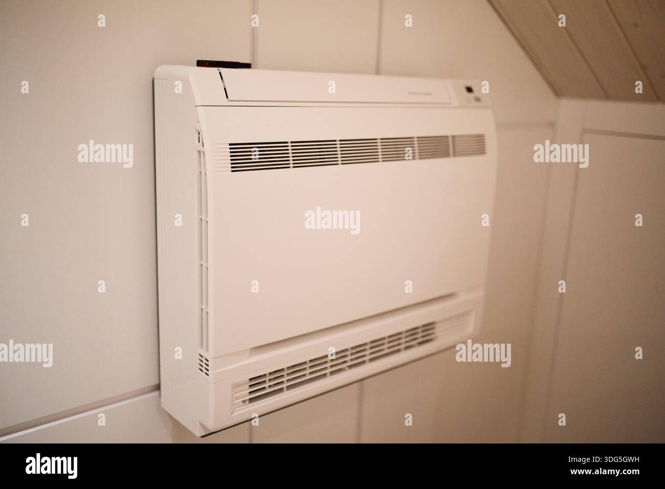 Modern wall-mounted air conditioner installed in a room, providing ...