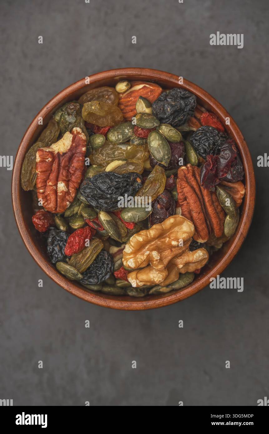 Different types of nuts, seeds and dried fruits on black background ...