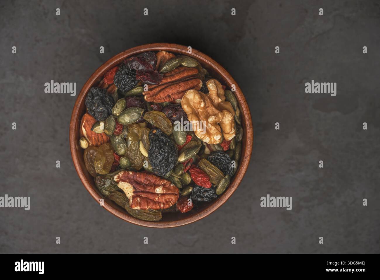 Different types of nuts, seeds and dried fruits on black background ...