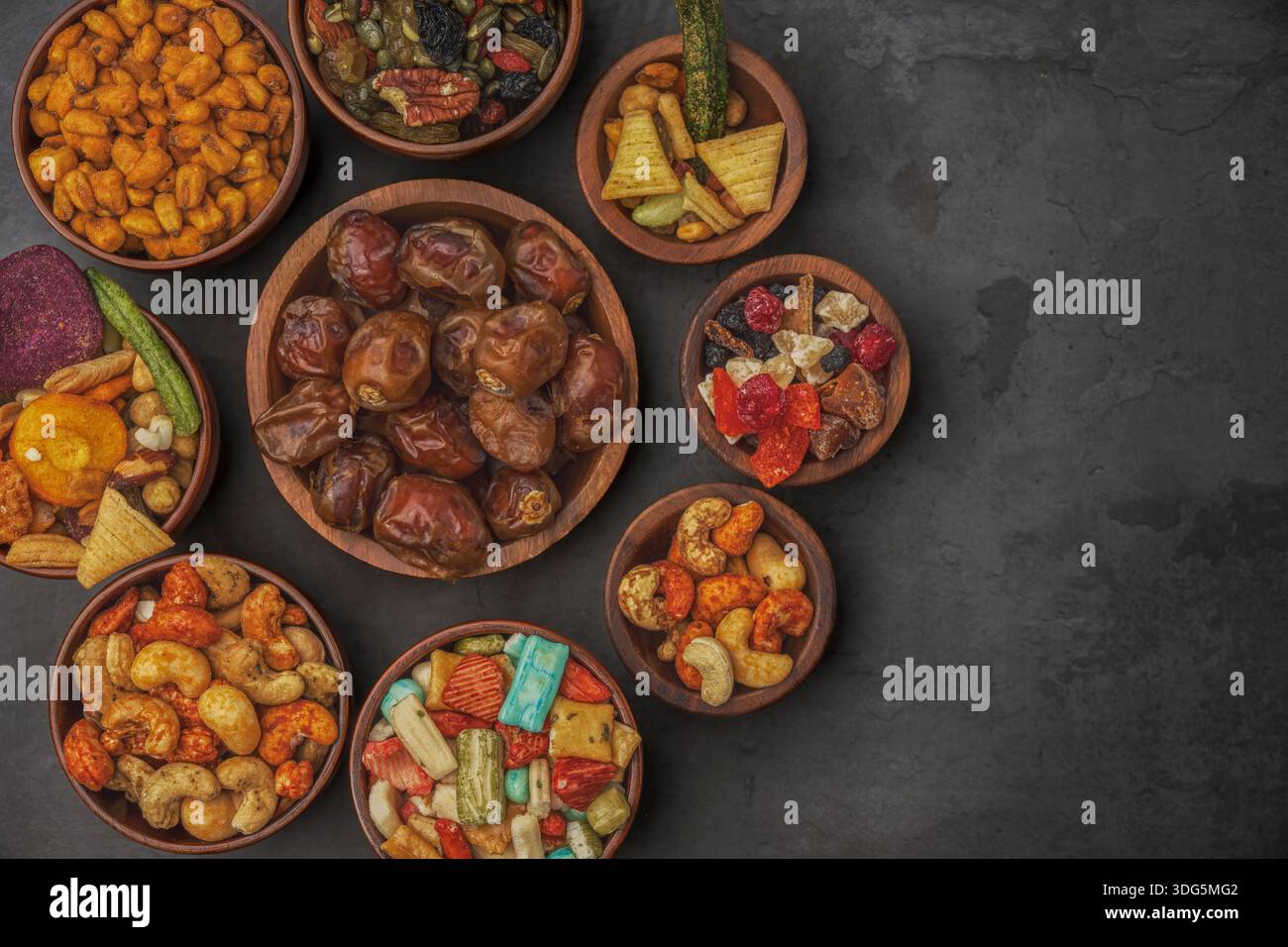 Different types of nuts, seeds and dried fruits on black background ...