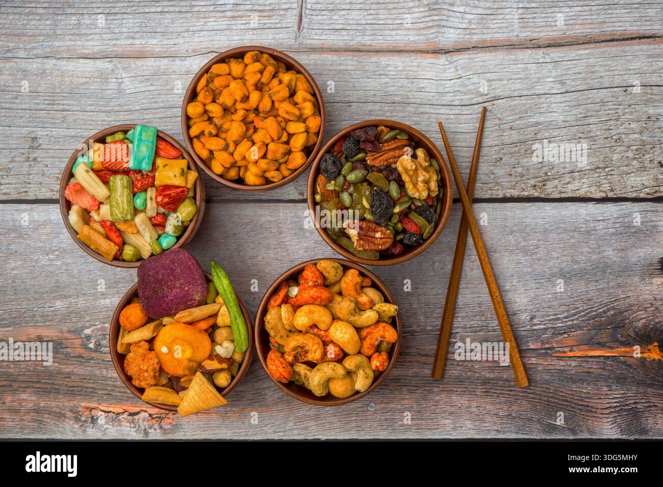 Different types of nuts, seeds and dried fruits on black background ...