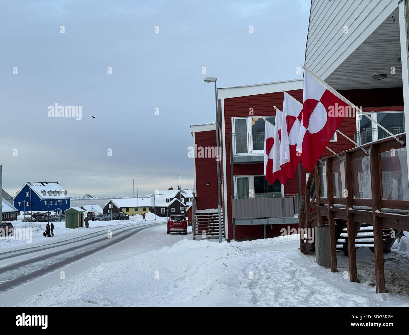 14 January 2026, Greenland, Nuuk: The Greenlandic flag on residential ...