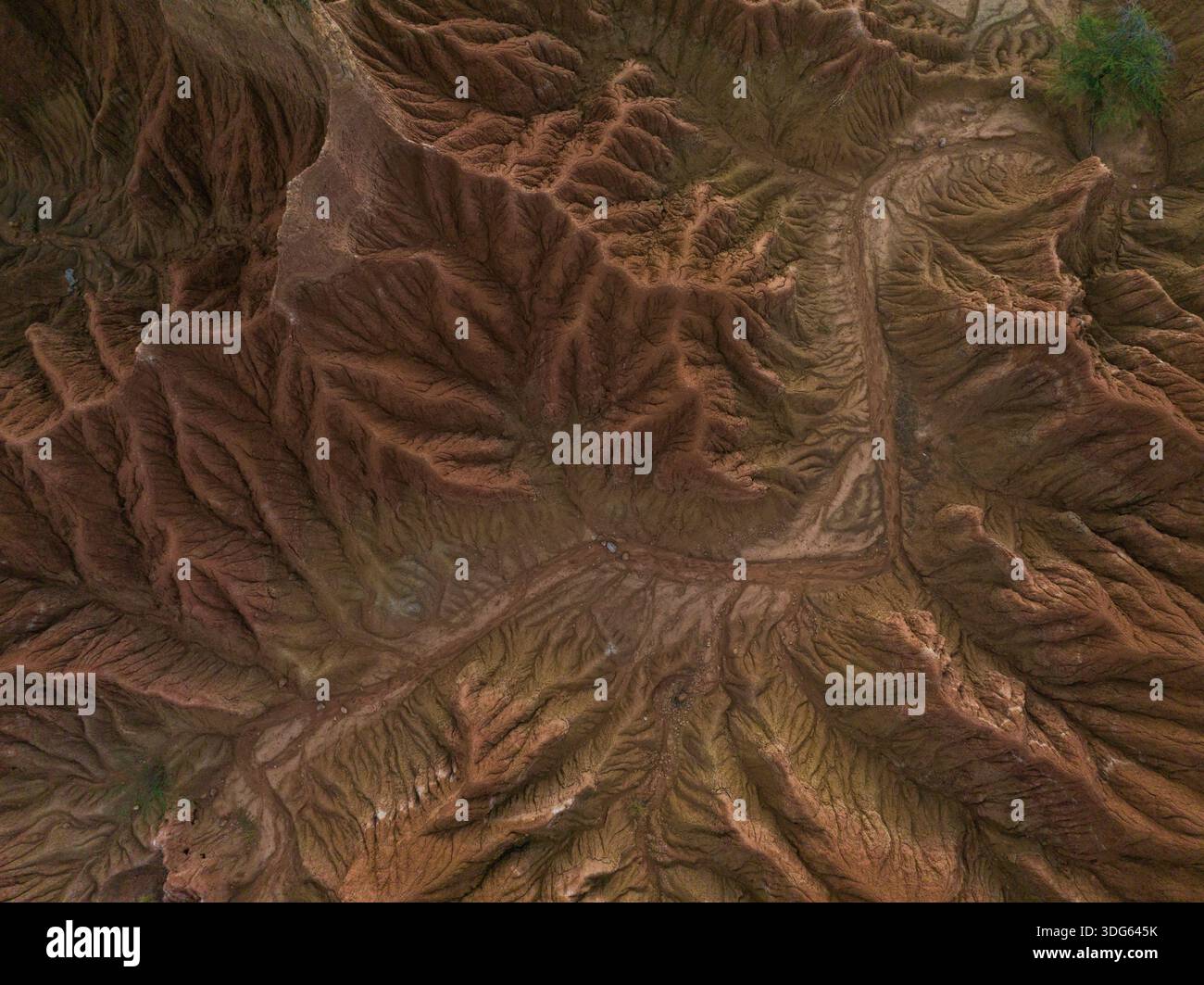 Aerial view of rugged, reddish-brown eroded canyon landscape with ...