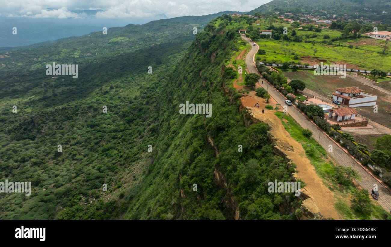 A aerial view of a lush green landscape with a winding road along a ...