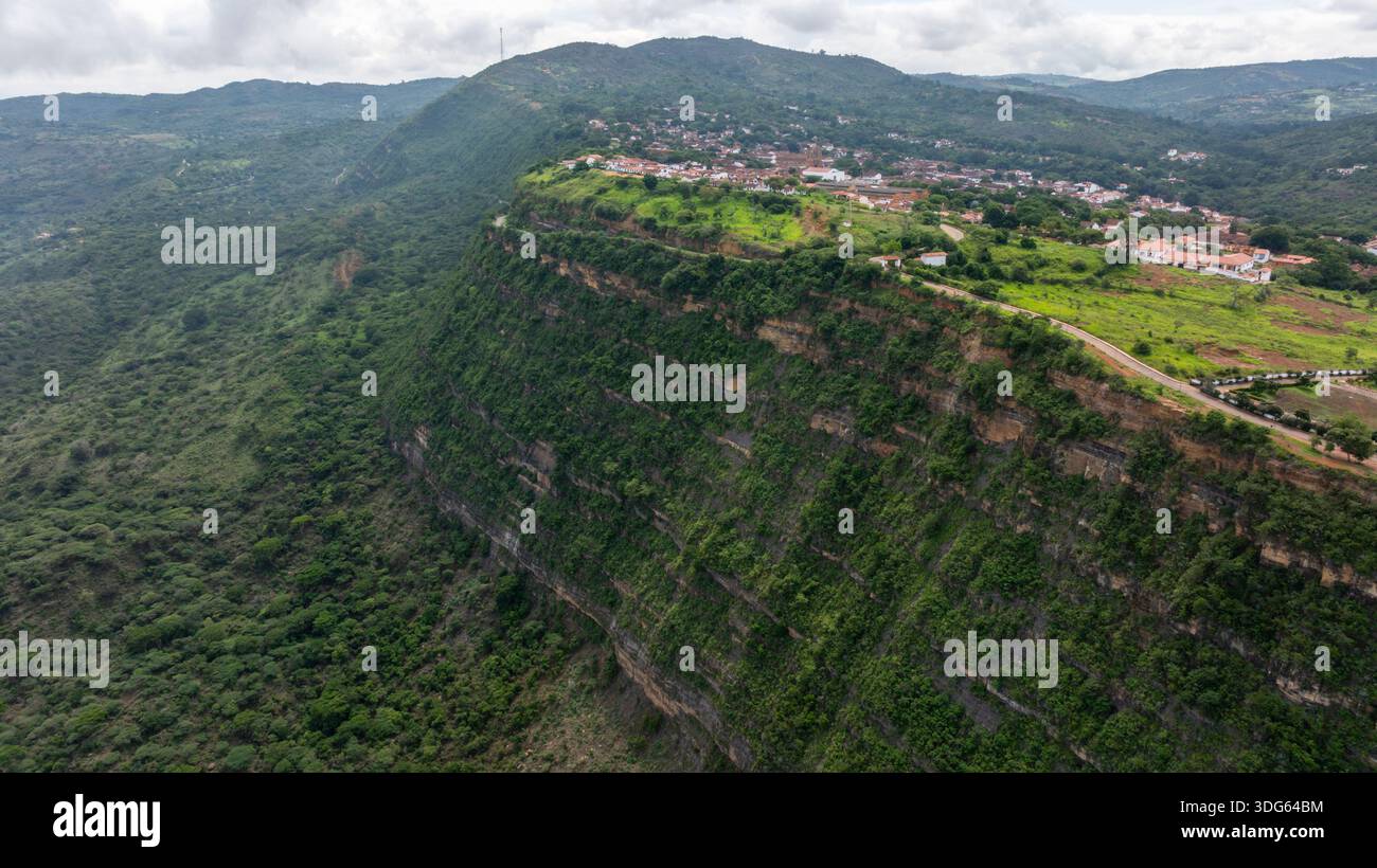 Aerial view of a green cliffside with a town nestled on top amidst a ...