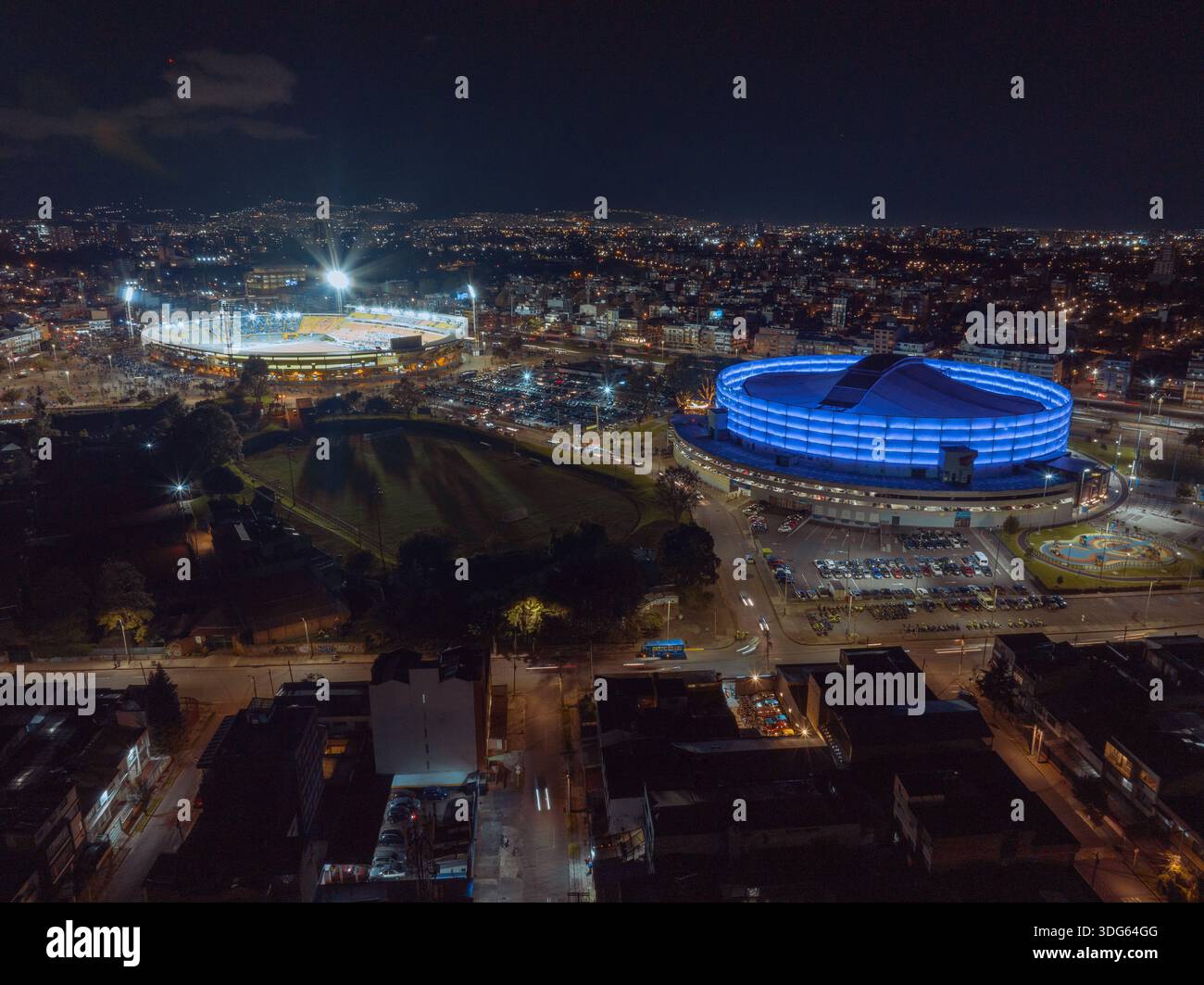 Aerial view of vibrant cityscape at night with illuminated stadiums and ...