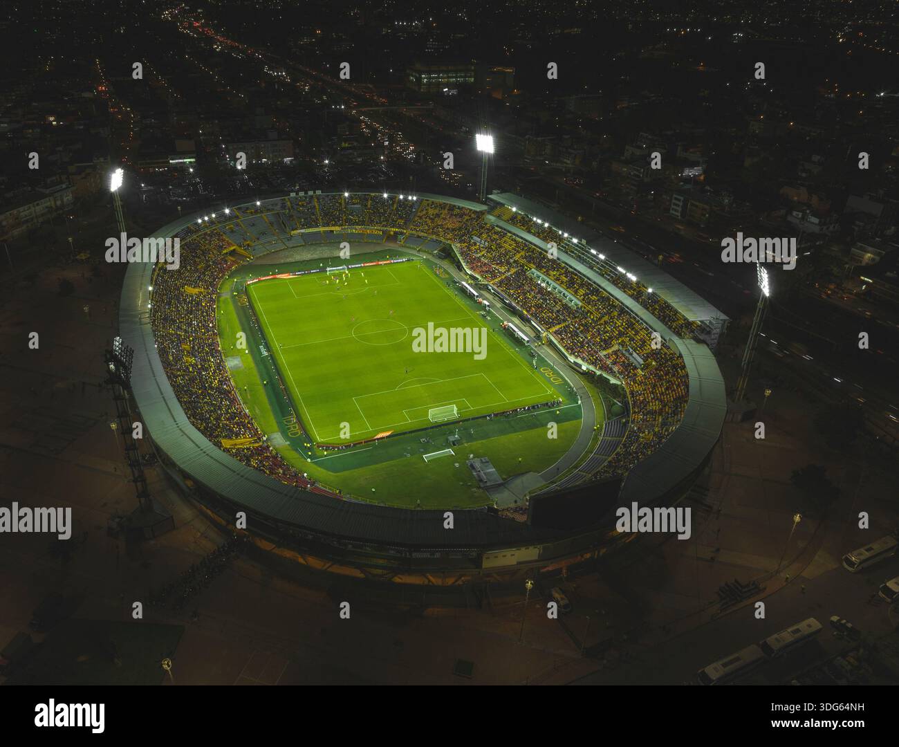 Night aerial view of an illuminated football stadium filled with ...