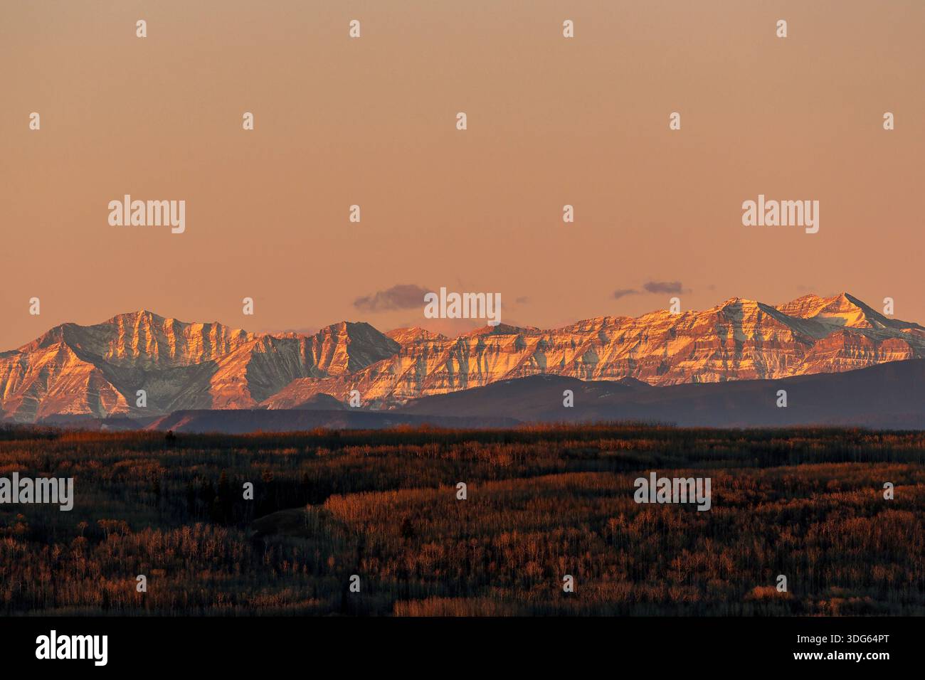 Majestic mountains at sunset with orange and pink hues in the clear sky ...