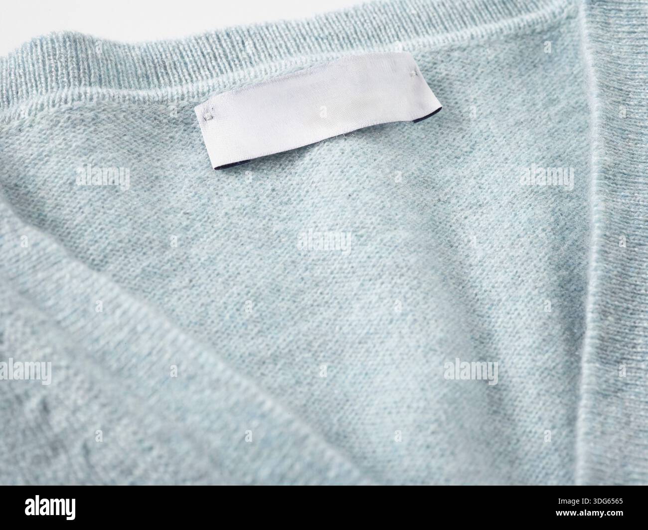 Close-up of light blue knitted sweater with blank label on collar Stock ...