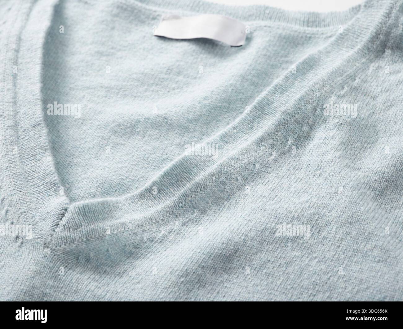 Light gray V-neck sweater close-up with visible texture and fabric ...
