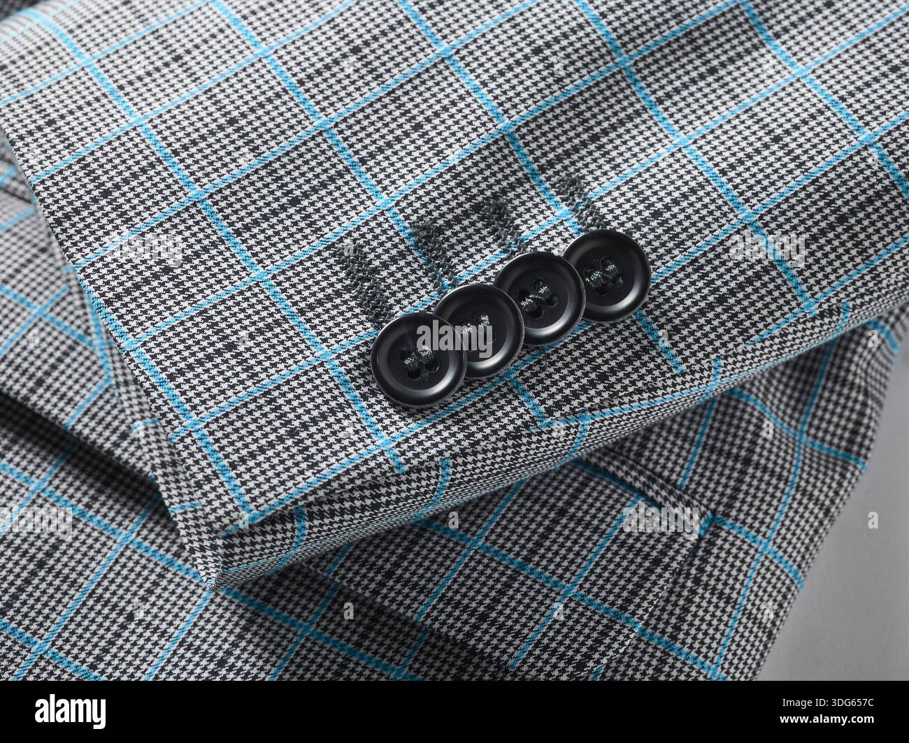 Close-up of a gray checkered suit sleeve with blue lines and black buttons Stock Photo - Alamy