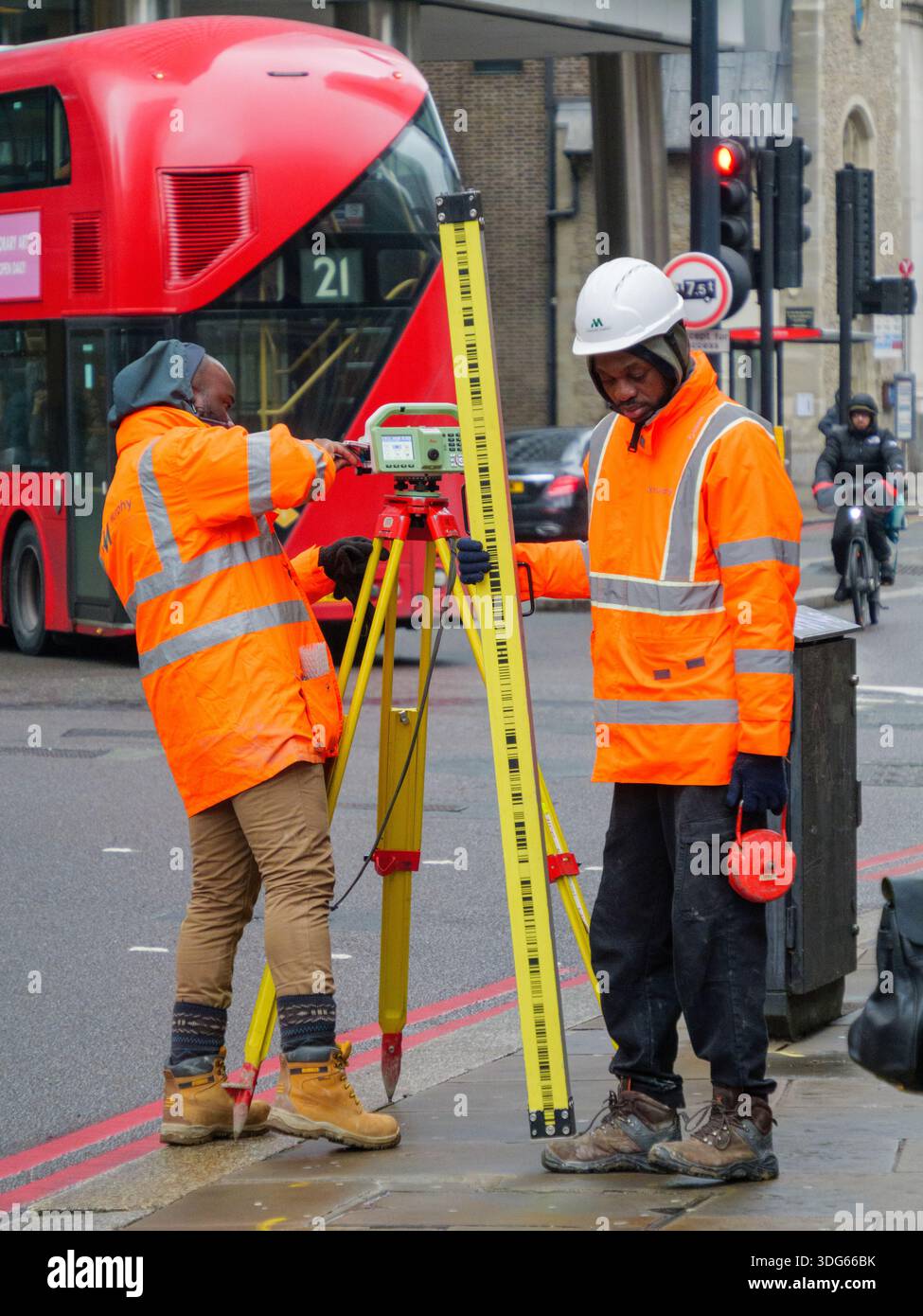 Surveyors use theodolite surveying instruments on a street in the City ...