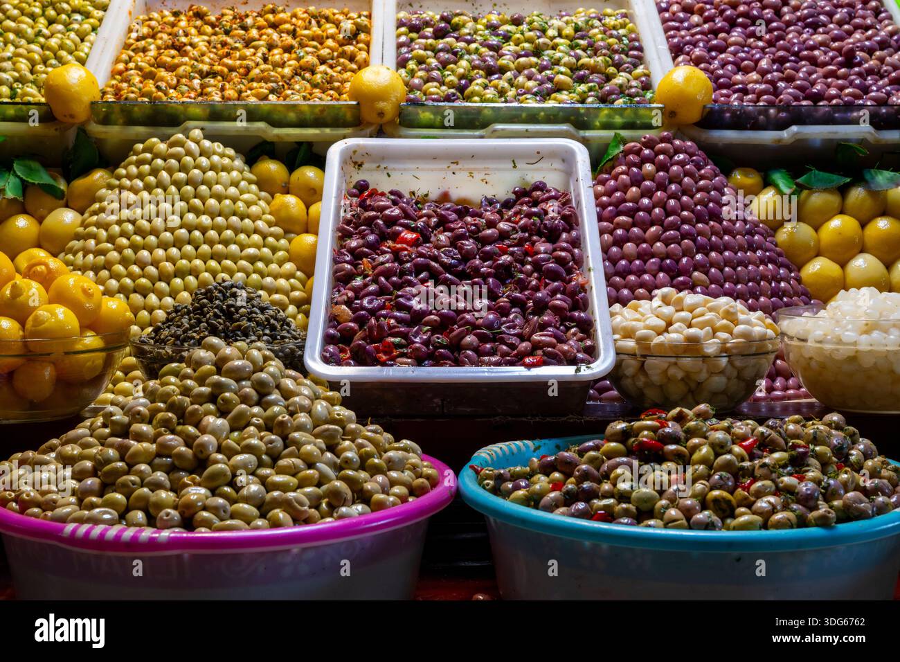 Vibrant display of assorted olives and pickles in colorful baskets at a ...