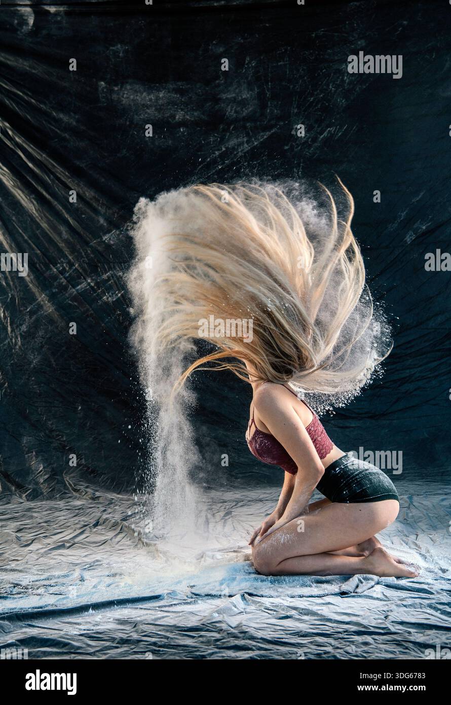 Woman tossing flour in the air with long hair in dynamic motion on a ...